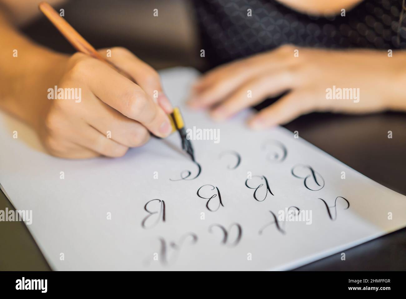 Calligrapher Young Woman writes phrase on white paper. Inscribing ...