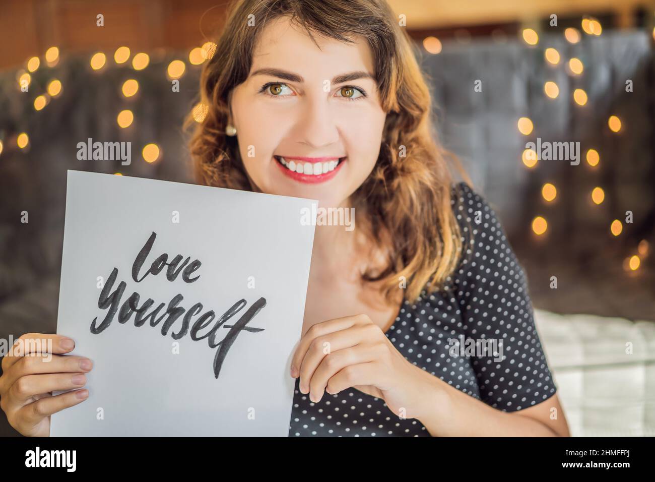Love yourself. Calligrapher Young Woman writes phrase on white paper ...