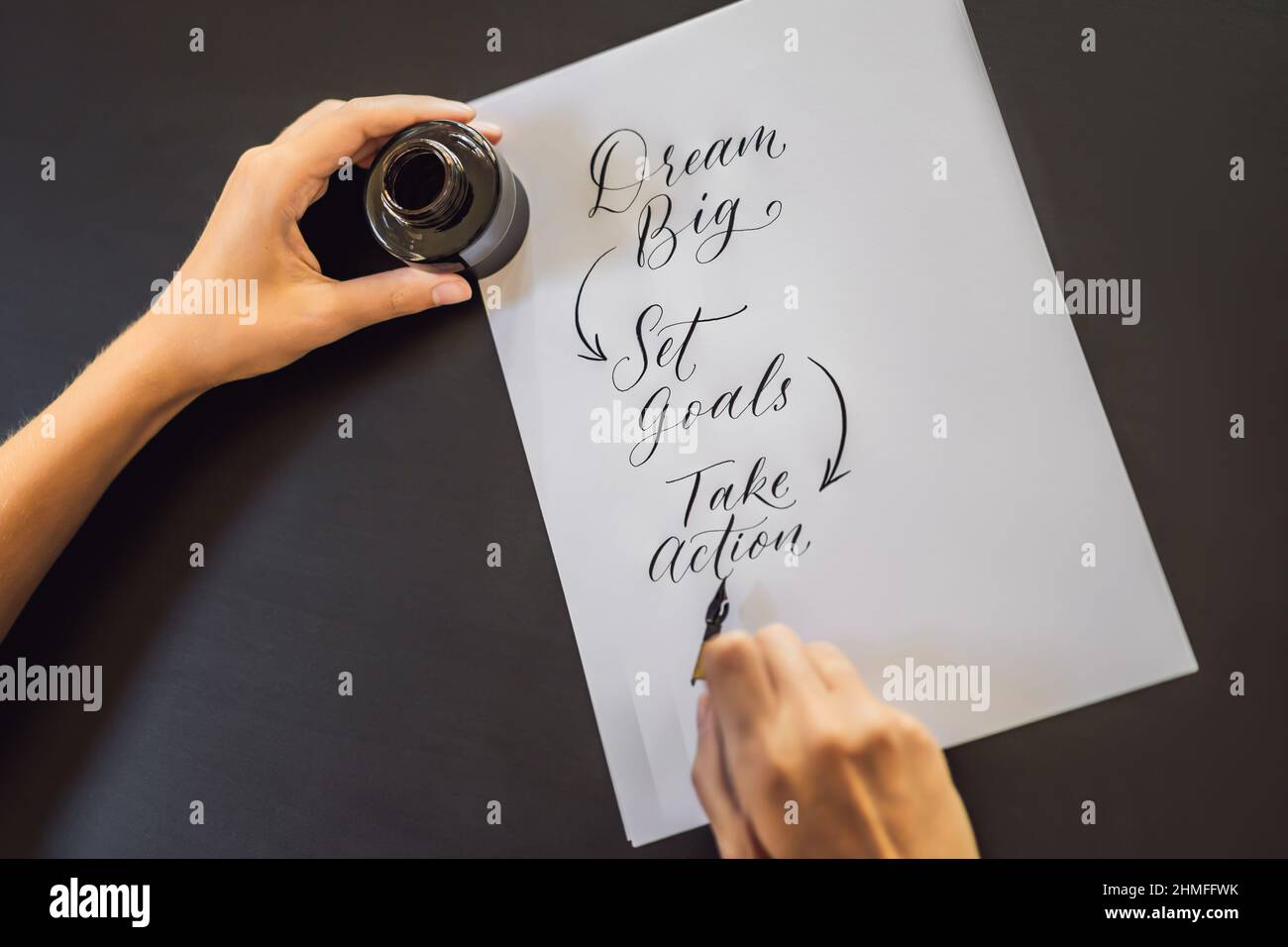 dream big set goals take action. Calligrapher Young Woman writes phrase ...