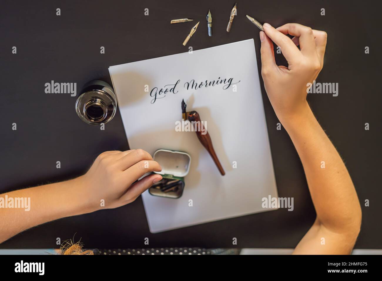 Good morning. Calligrapher Young Woman writes phrase on white paper ...