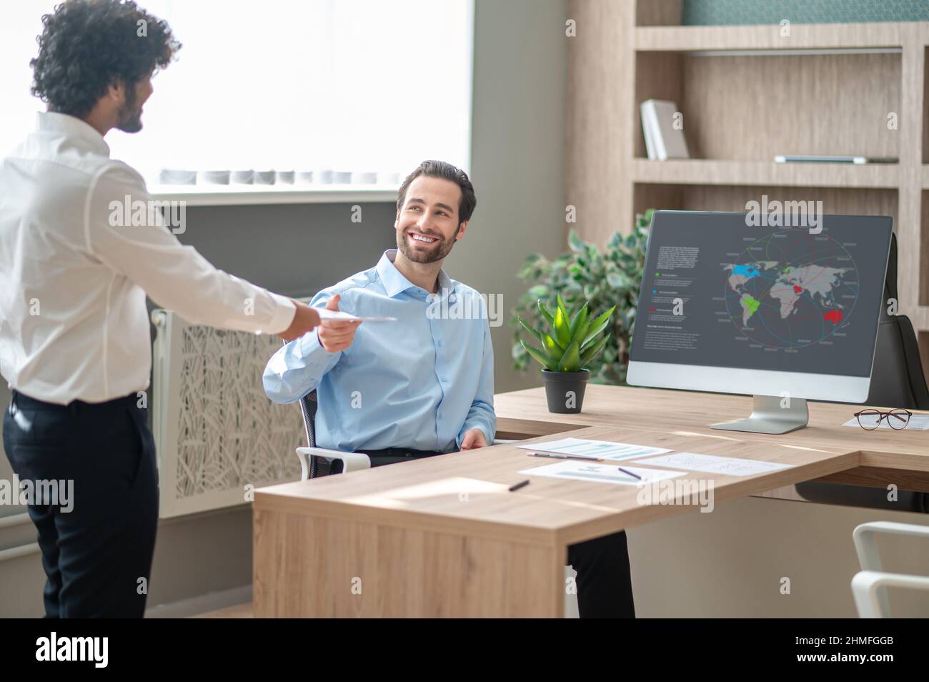 Manager meeting a client and shaking his hand Stock Photo - Alamy