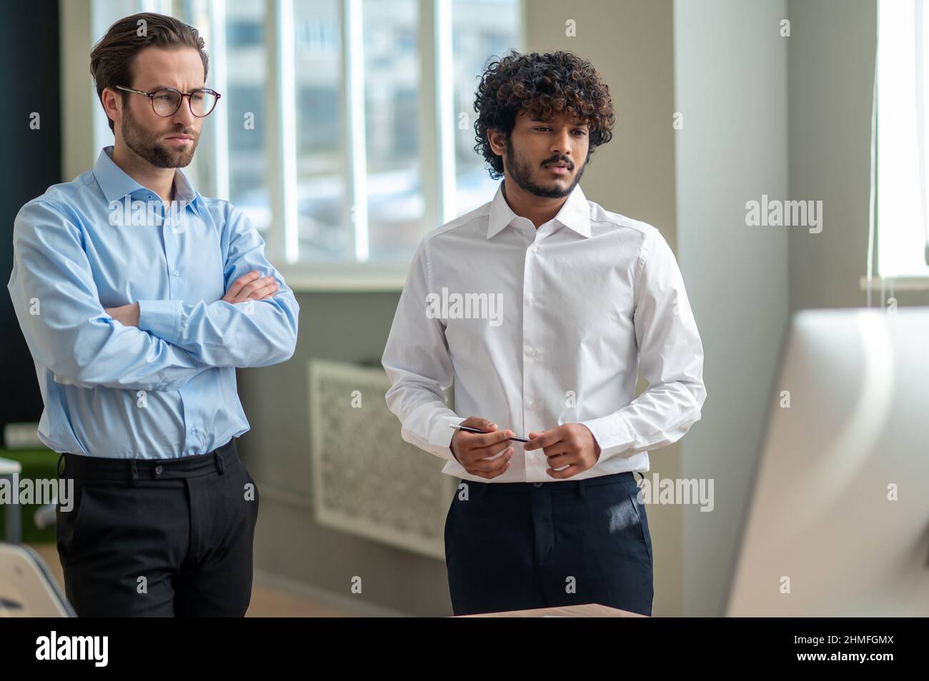 Two men standing in front of camera and looking involved Stock Photo ...