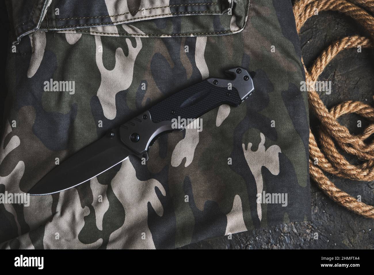 Tactical folding knife for survival and rope on camouflage military ...