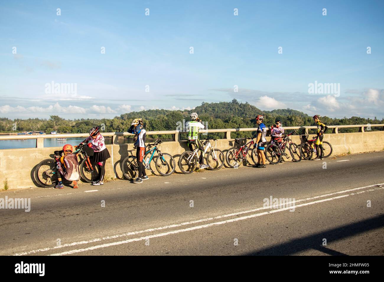 Cyclist on the Mengkabong bridge overlooking the Mengkabong river ...