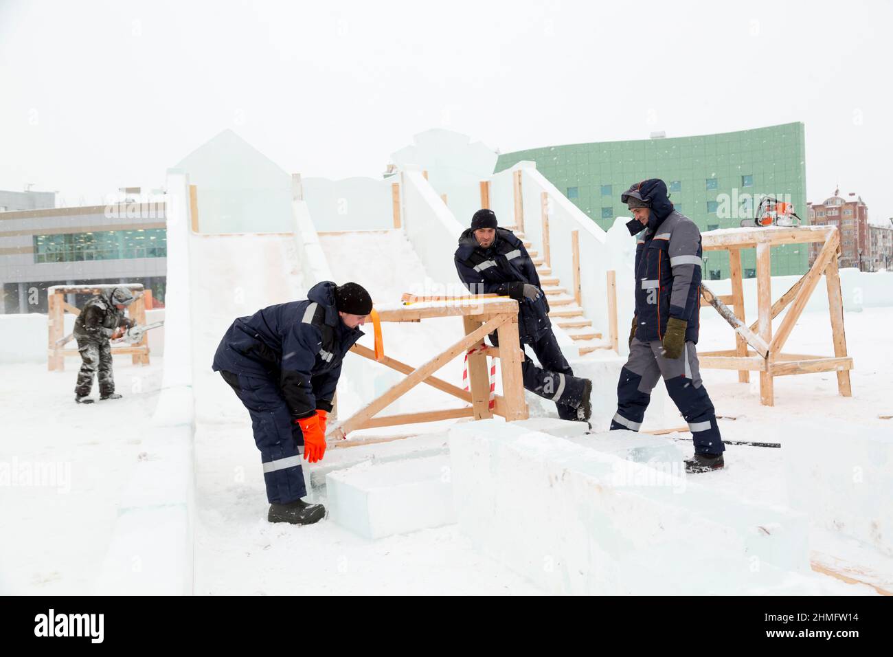Installers build an ice slide at the construction site of the ice town ...
