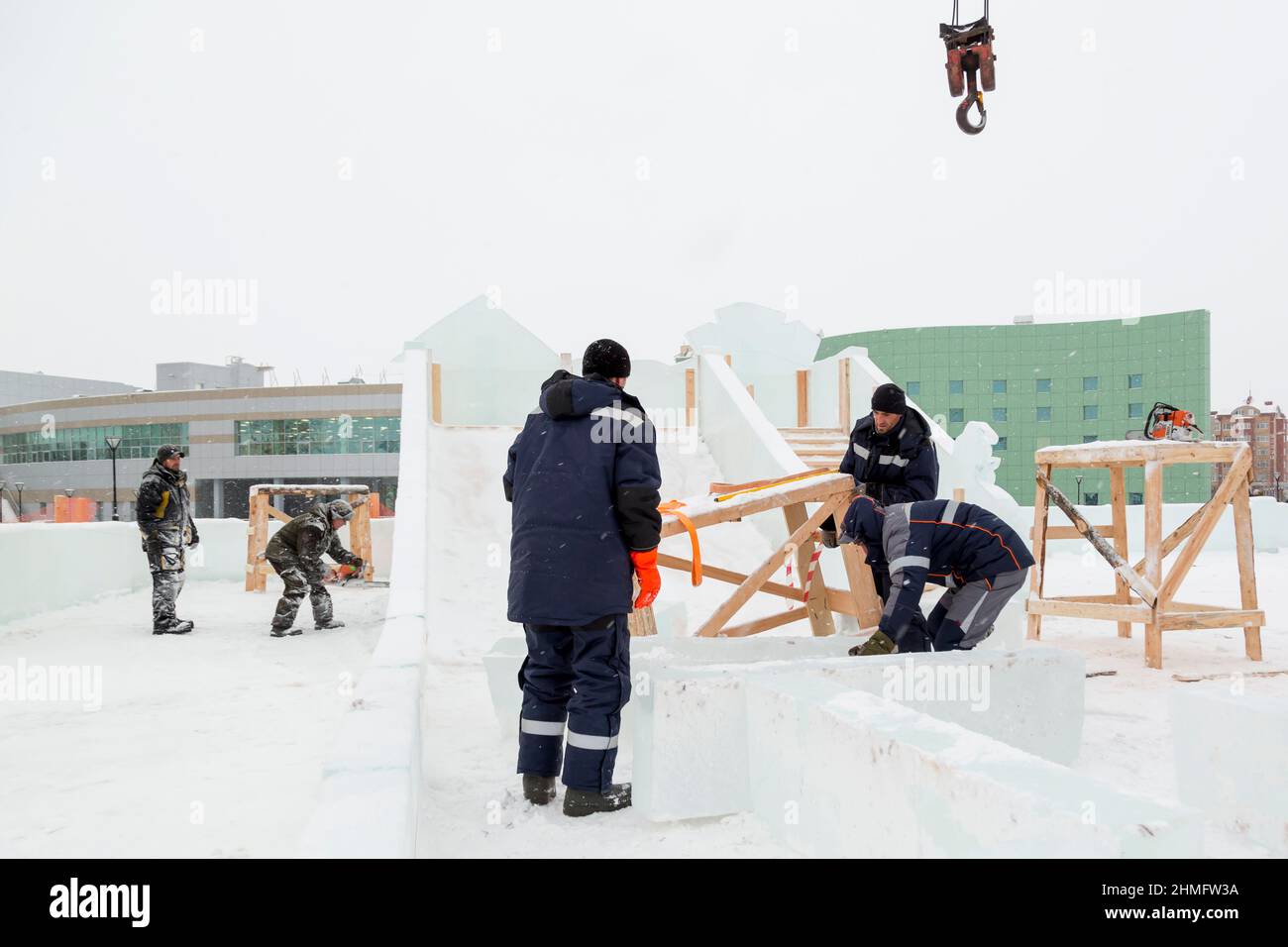 Installers build an ice slide at the construction site of the ice town ...