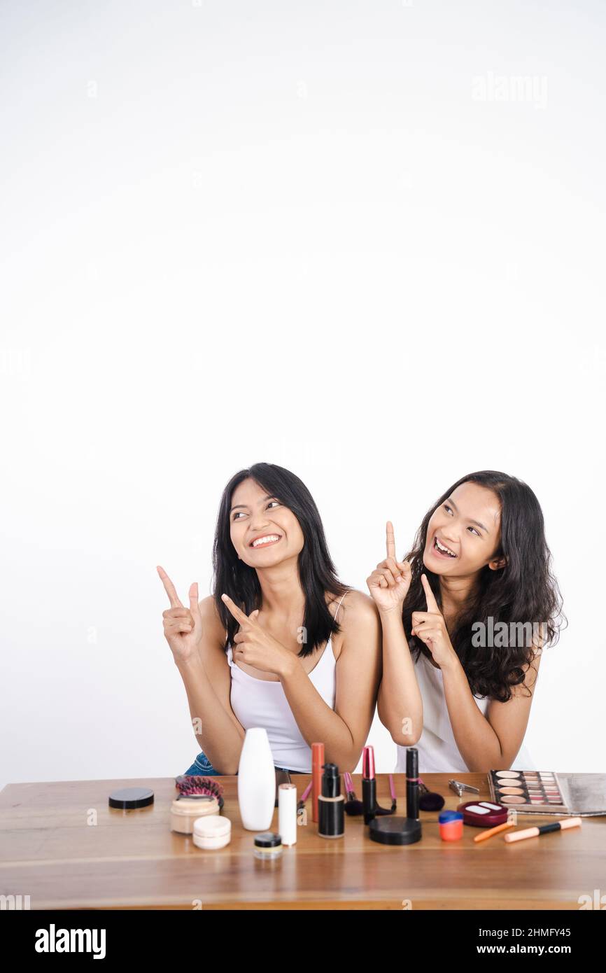 asian Female friends putting makeup pointing up Stock Photo - Alamy