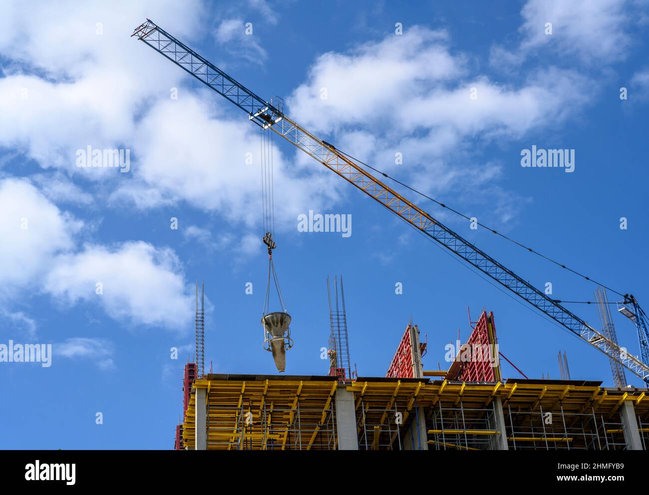 The boom of a crane feeding concrete on the construction of a high-rise ...