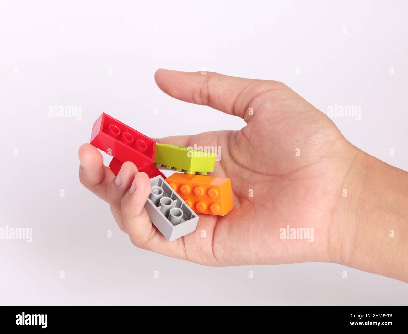 hand holding brick toys, isolated white background Stock Photo - Alamy