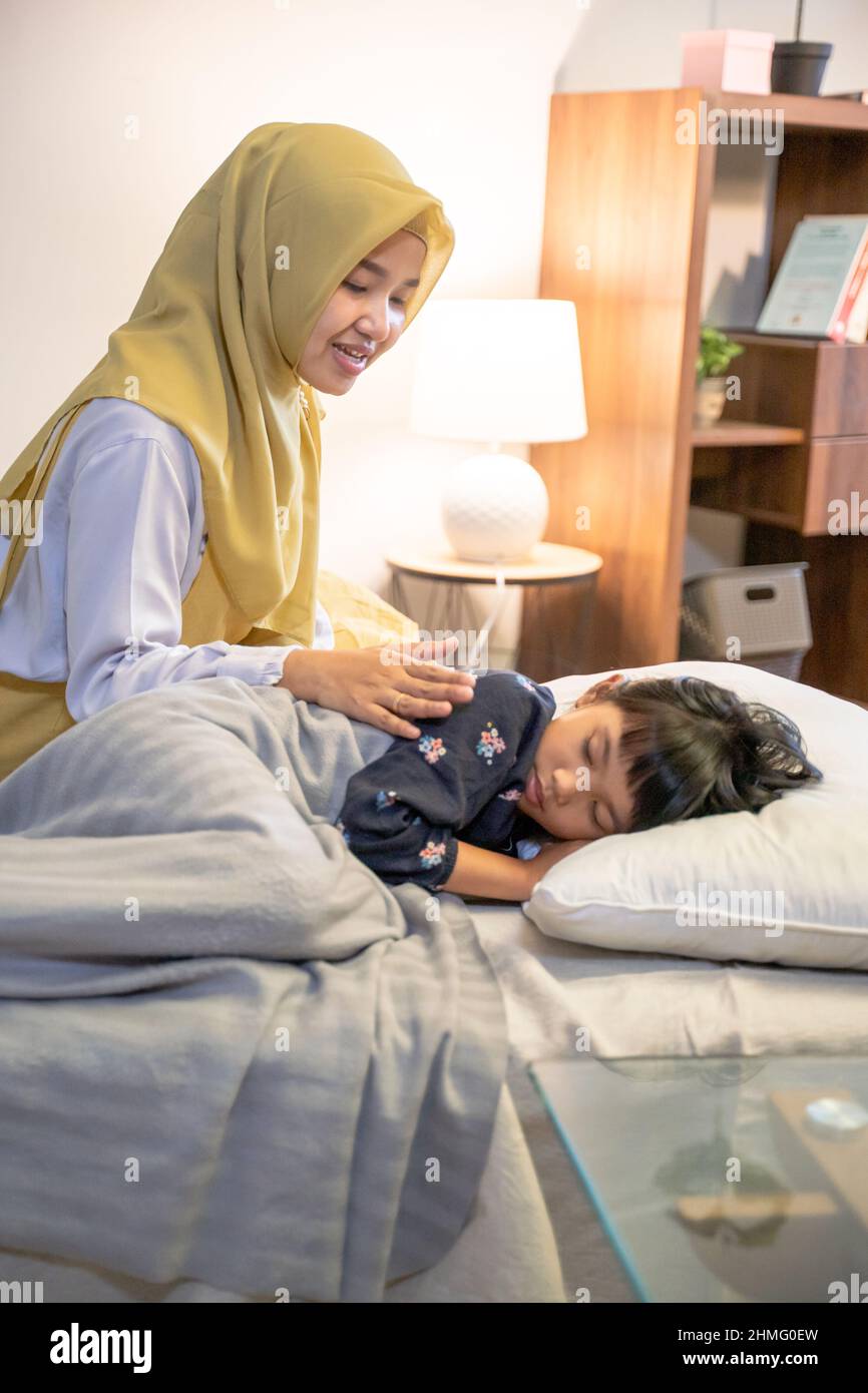 muslim mother waking her daughter up in the bed Stock Photo - Alamy