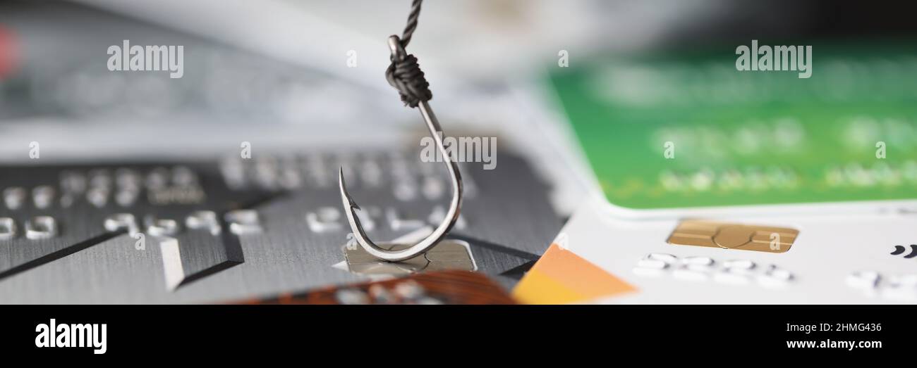 Fishing hook is hooked on plastic bank credit card closeup Stock Photo ...