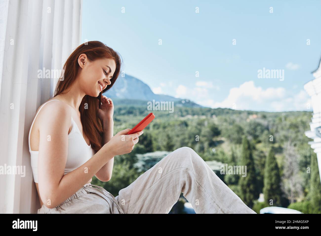 beautiful woman with long hair on an open balcony Green nature summer ...