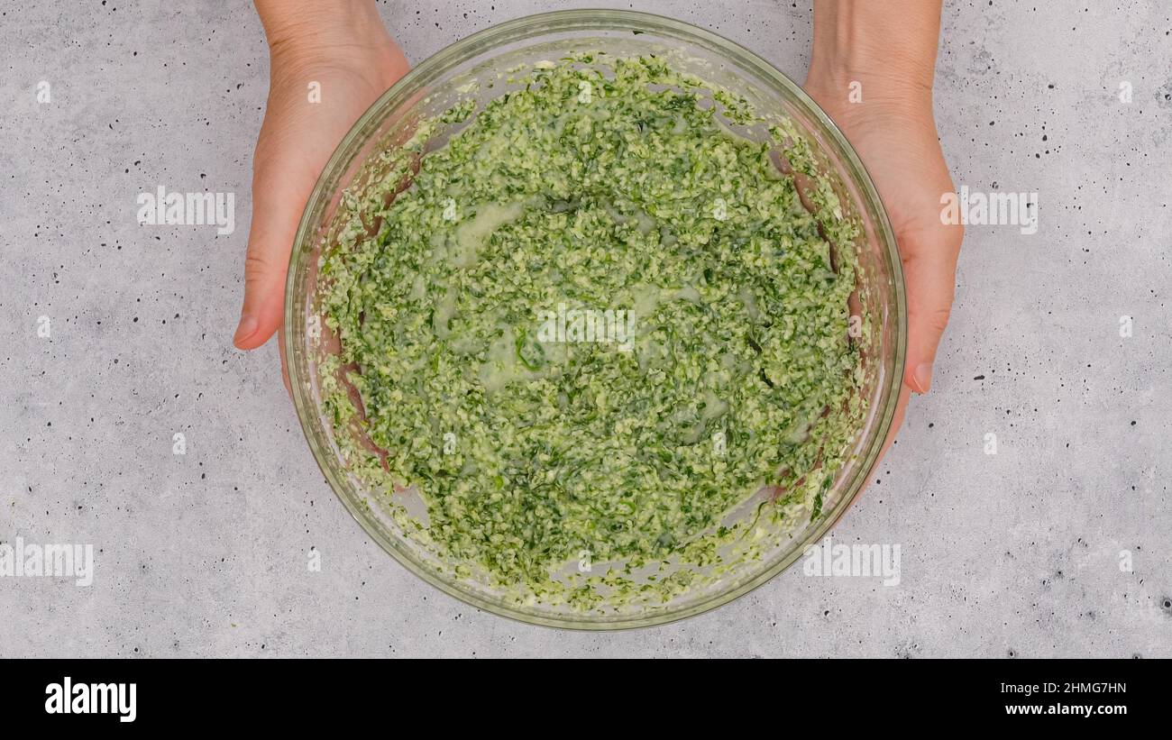 Mascarpone and spinach mix close up in a glass bowl on light grey ...