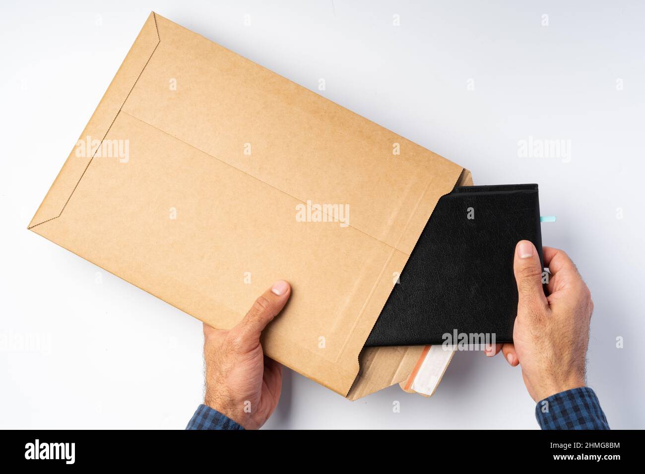 Top view of male hands hold (open) an envelope above white background ...