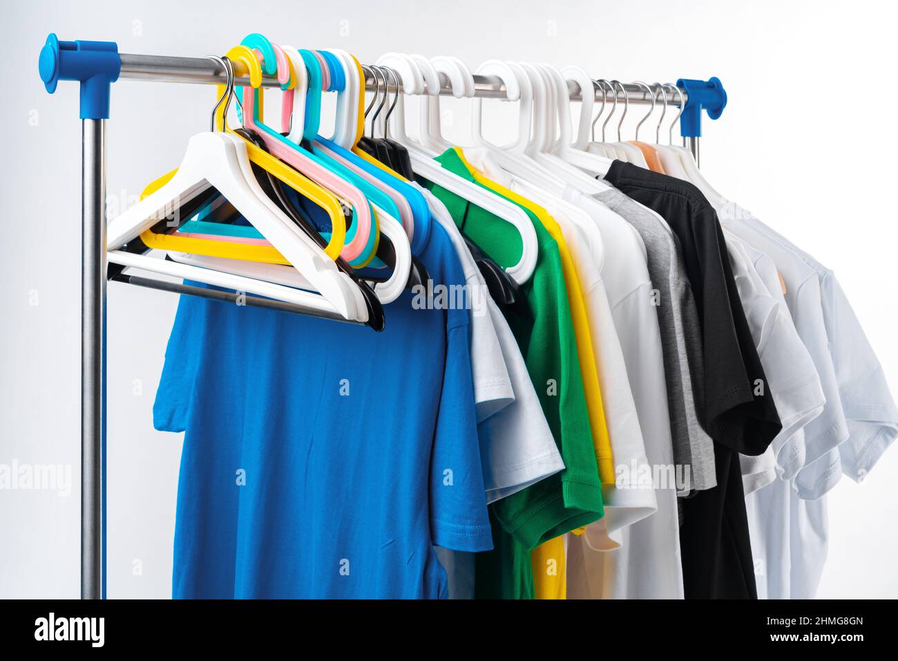 Clothes hang on clothing rack over white background Stock Photo - Alamy