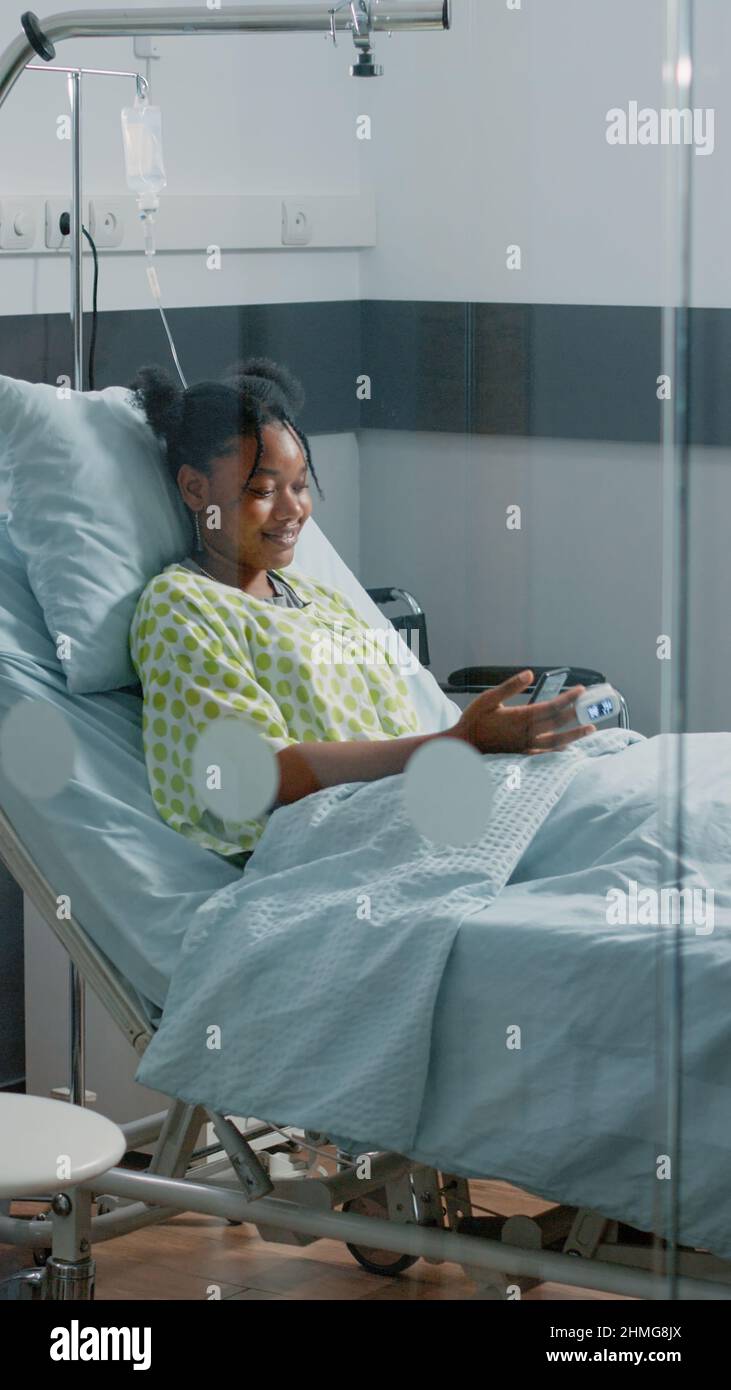 Ill patient holding mobile phone to talk on video call communication ...