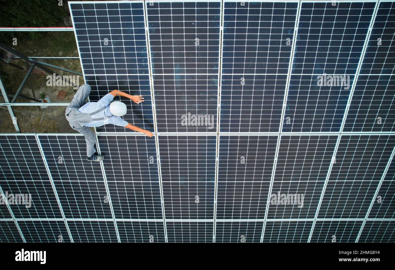 Male worker in safety helmet installing photovoltaic solar panel. Man ...