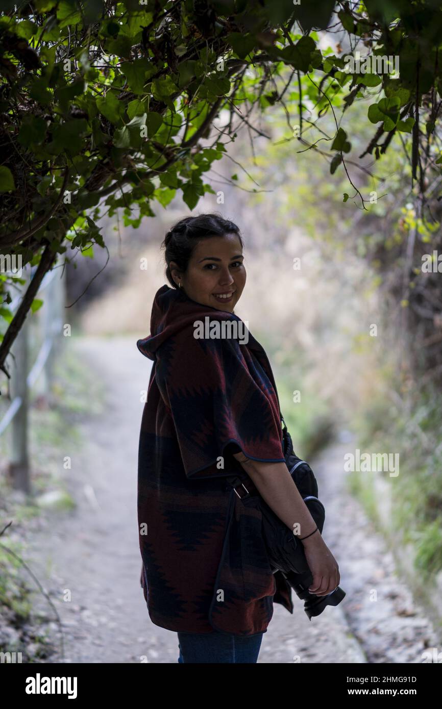 Caucasian female traveler poses below a green foliage Stock Photo - Alamy