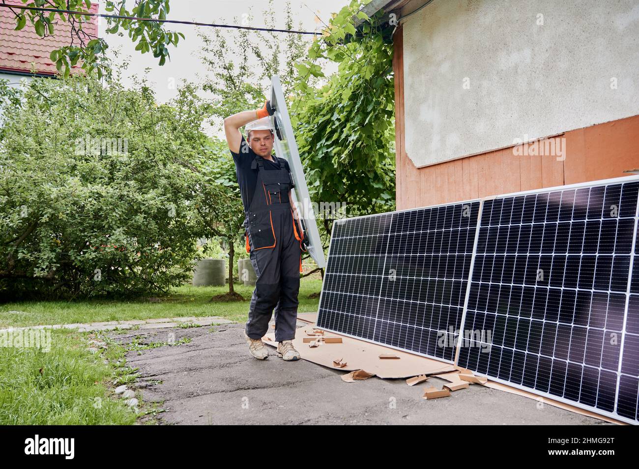 Worker holding and carrying solar panel for installing. Renewable and ...