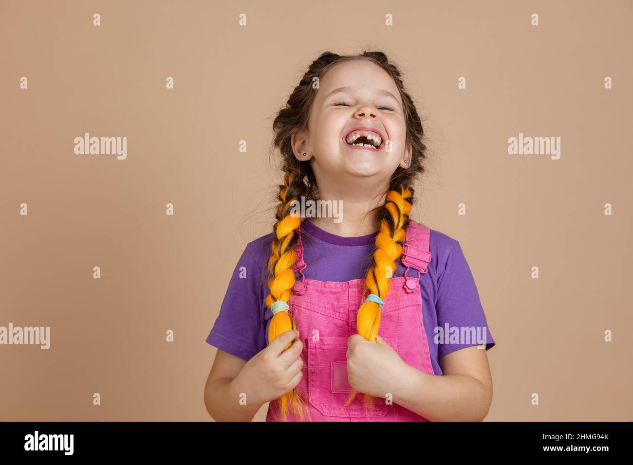 Portrait of young girl with kanekalon braids of yellow laughing out ...