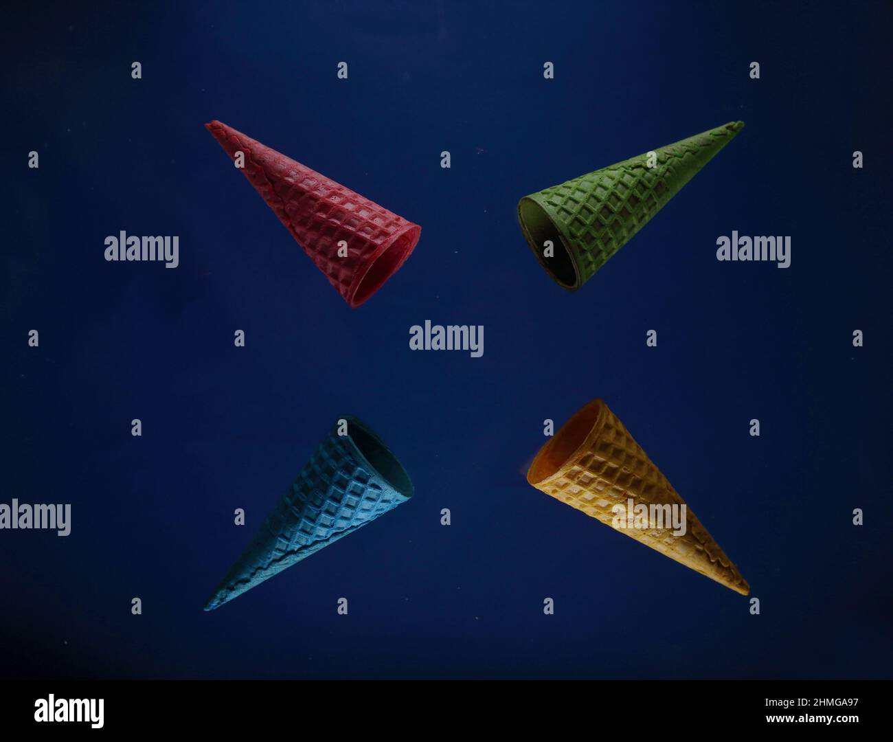 four waffle cones of different colours isolated against blue background ...