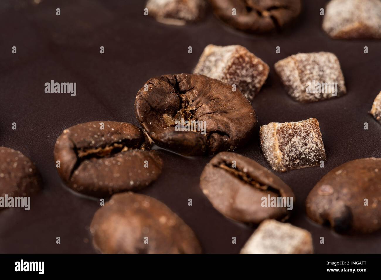 Close up of dark chocolate bar with coffee beans and candied fruit ...