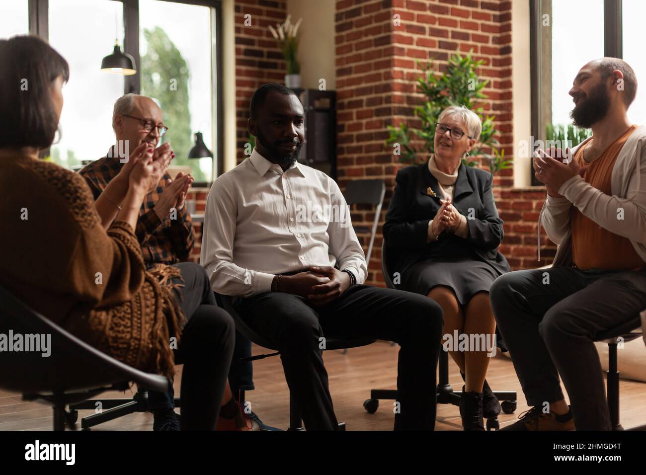 Group of people at aa meeting applauding success of man celebrating ...
