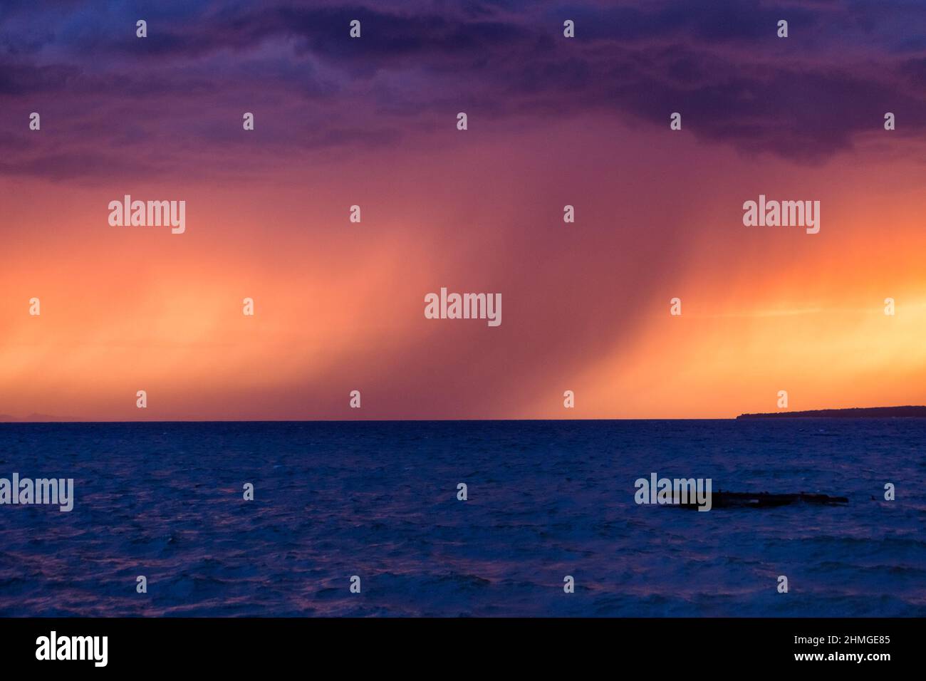 Sunset at sea during storm and rain Stock Photo - Alamy