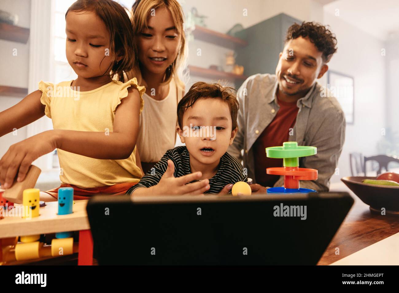 Young boy speaking expressively on a video call. Happy family of four ...