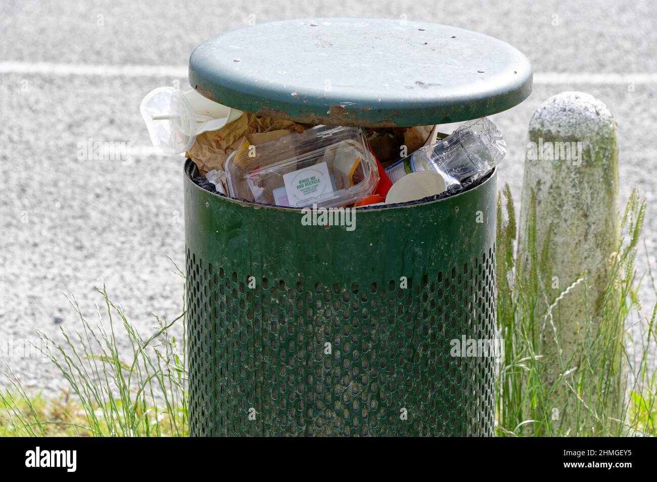 An over flowing rubbish bin beside a road Stock Photo - Alamy