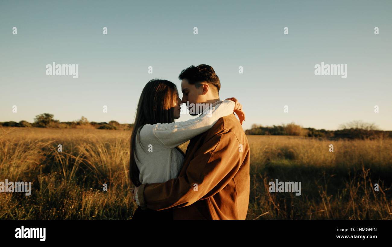Romantic Couple Hugging in a field at sunset light Stock Photo - Alamy