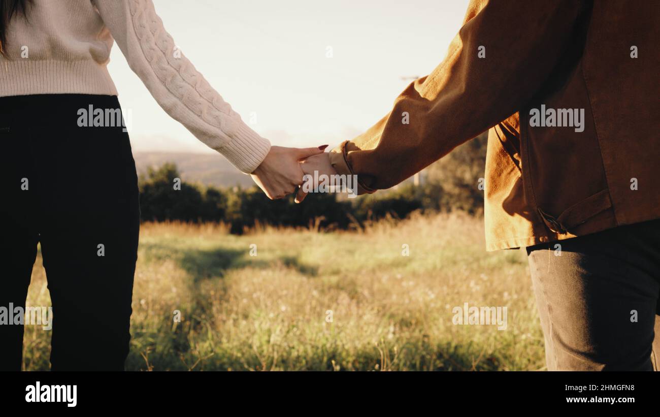Romantic Couple Walks Hand In Hand outdoor Stock Photo - Alamy