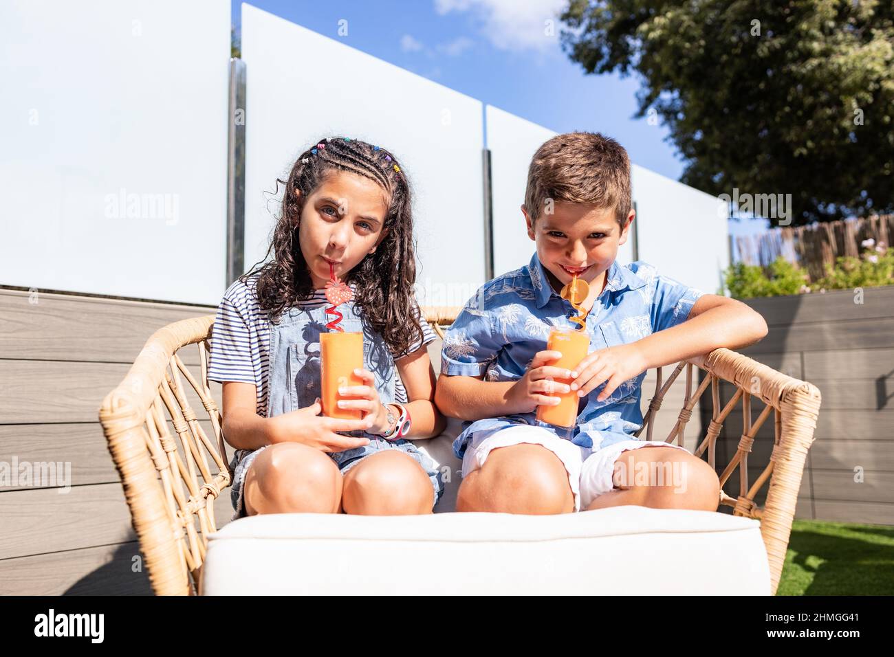 Two cute kids drinking orange juice outdoors Stock Photo - Alamy