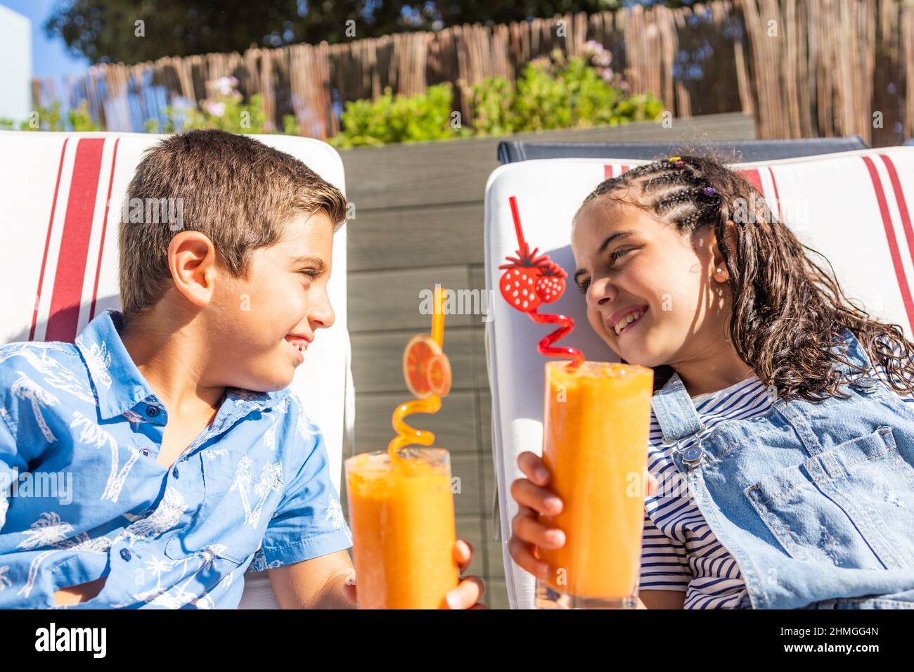 Two funny kids making a toast with orange juice Stock Photo - Alamy