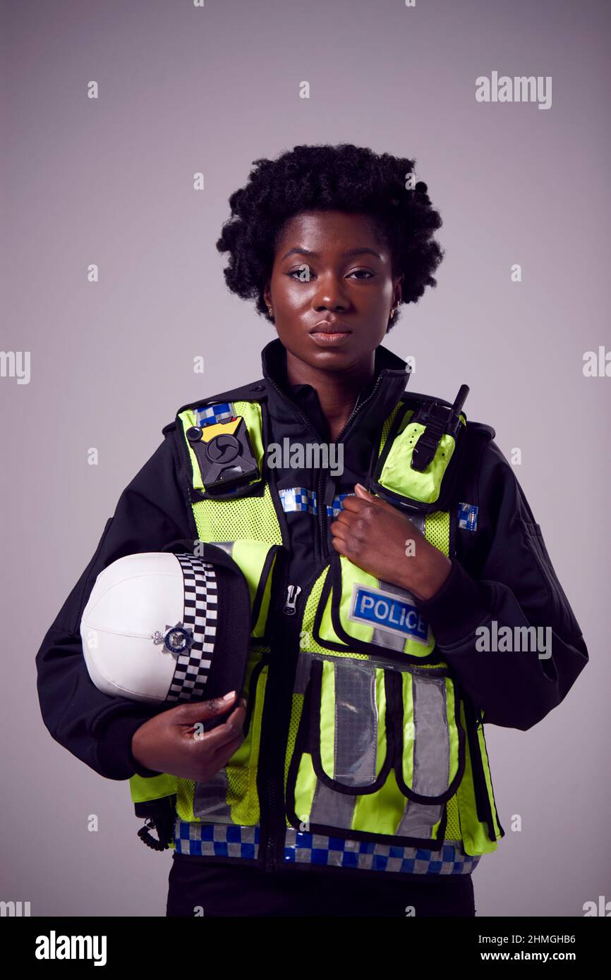 Studio Portrait Of Serious Young Female Police Officer Against Plain ...