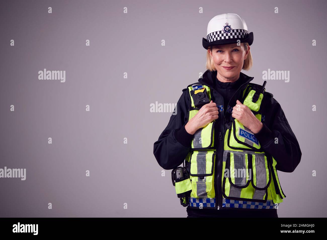 Studio Portrait Of Smiling Mature Female Police Officer Wearing Hat ...