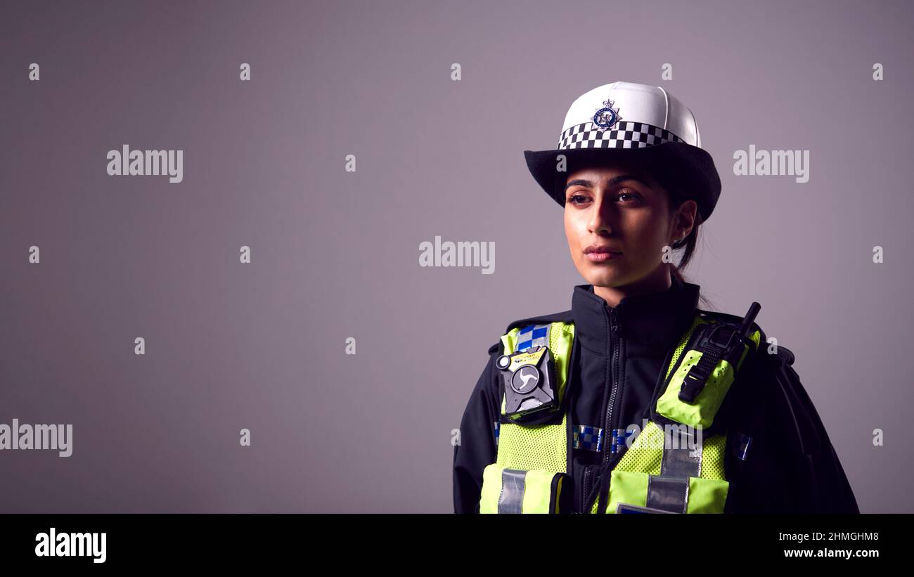 Studio Portrait Of Serious Young Female Police Officer Against Plain ...