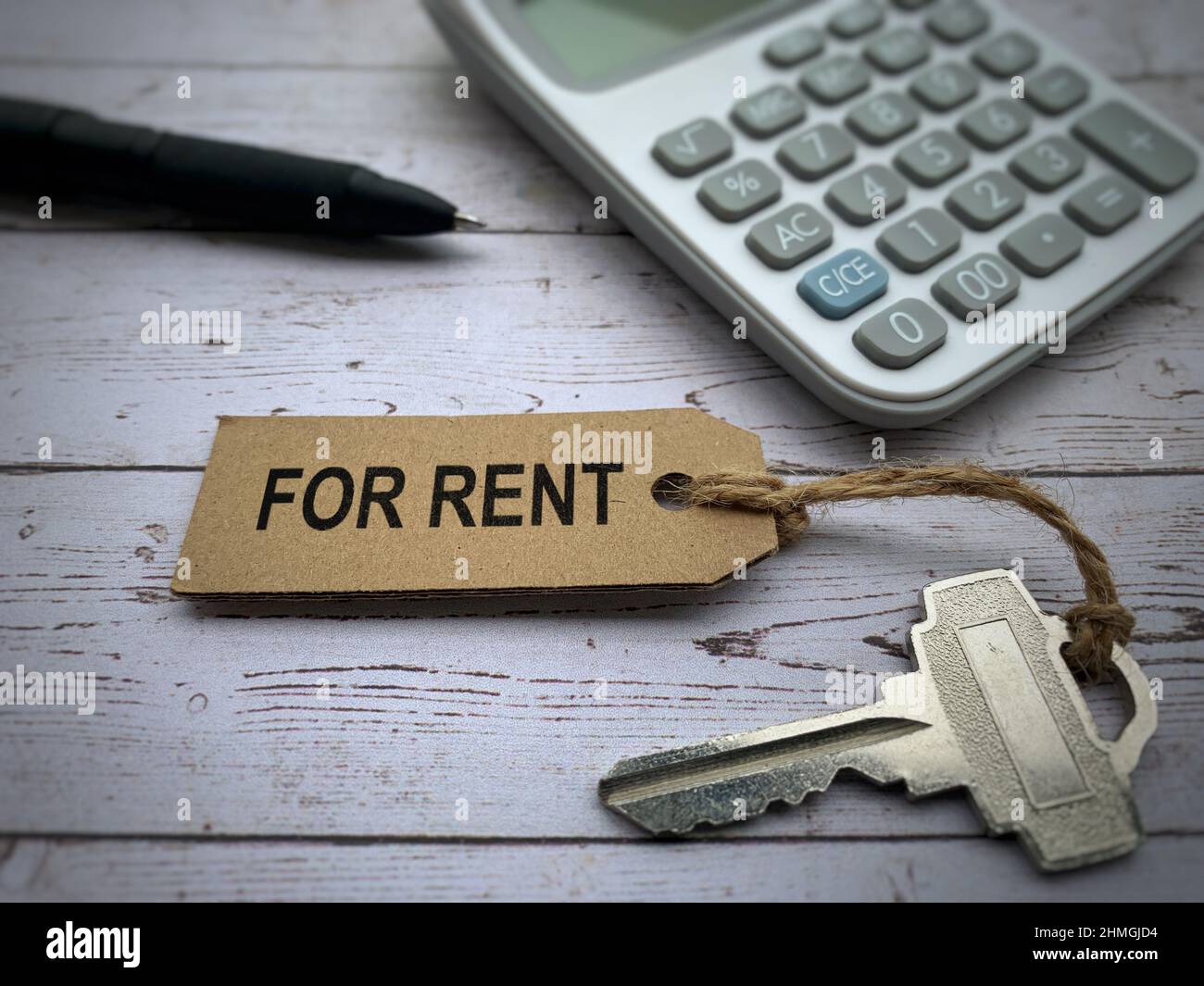 For rent text on key chain with calculator and pen background. Home ...