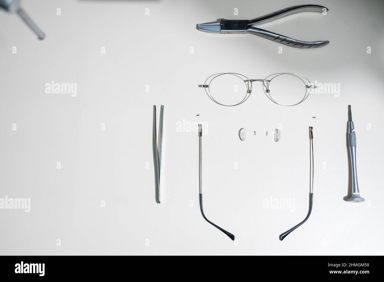 Disassembled glasses frame and tools. Optics work table Stock Photo - Alamy