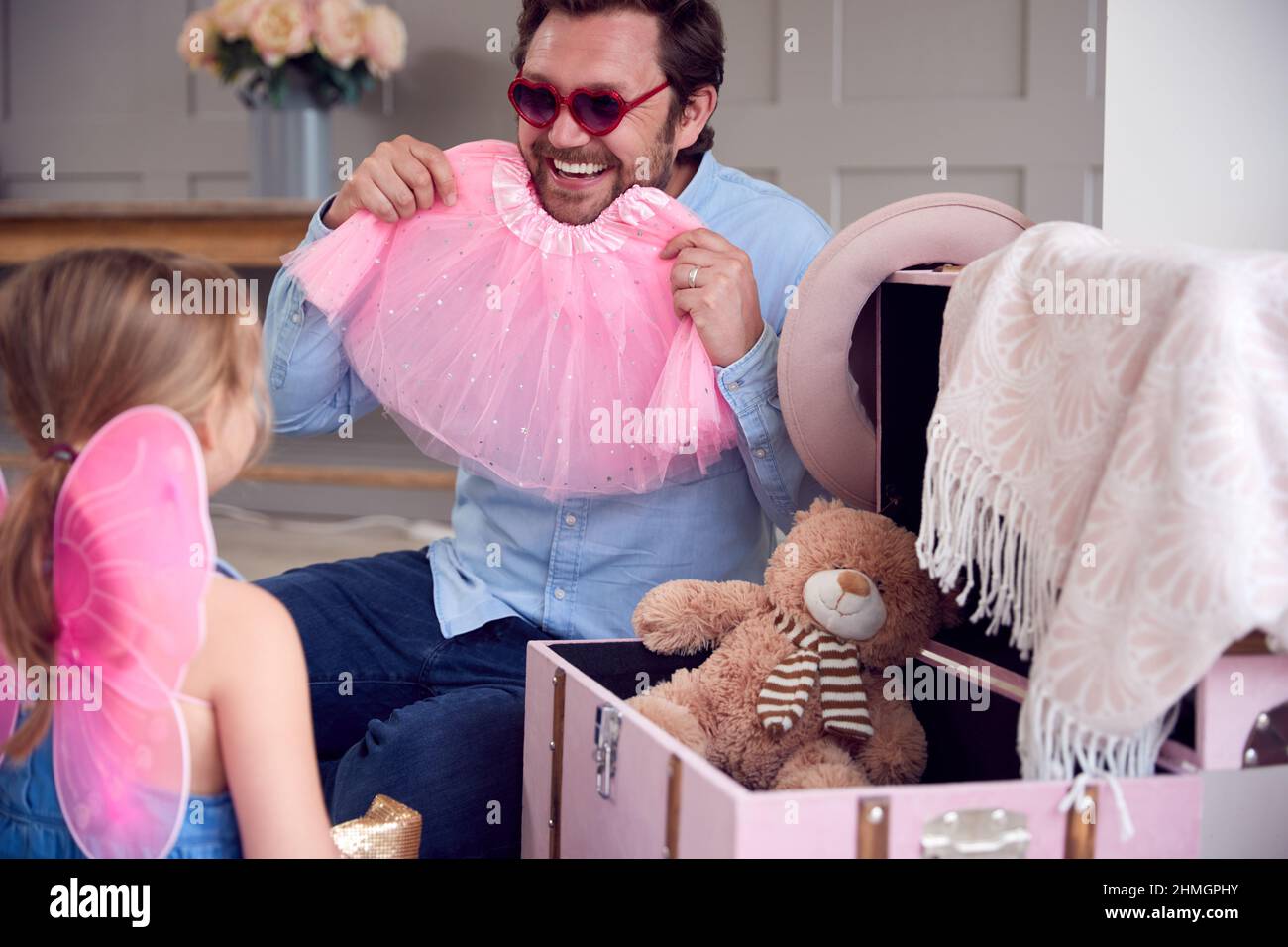 Father And Daughter Having Fun Playing With Dressing Up Box At Home ...