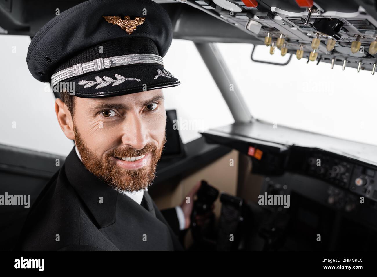 cheerful pilot in cap looking at camera in airplane simulator Stock ...