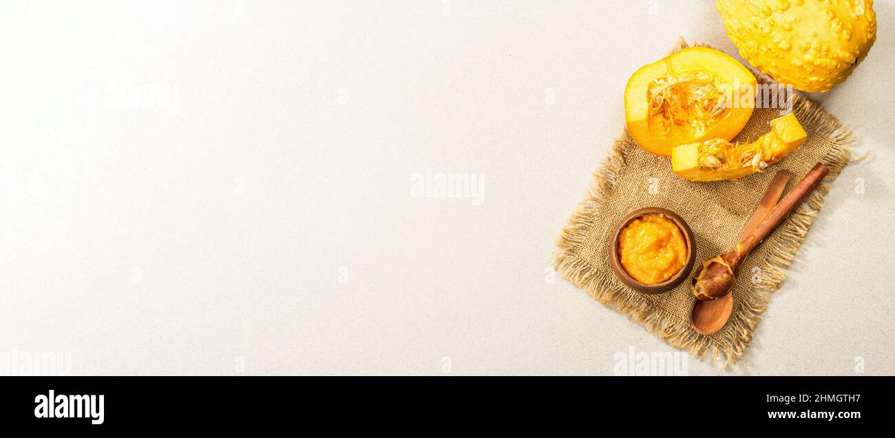 Autumn food cooking concept. Pumpkin puree, whole and cut pumpkins ...