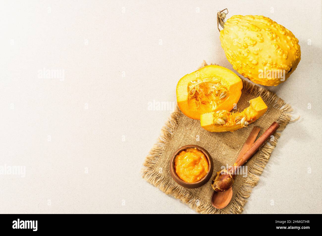 Autumn food cooking concept. Pumpkin puree, whole and cut pumpkins ...