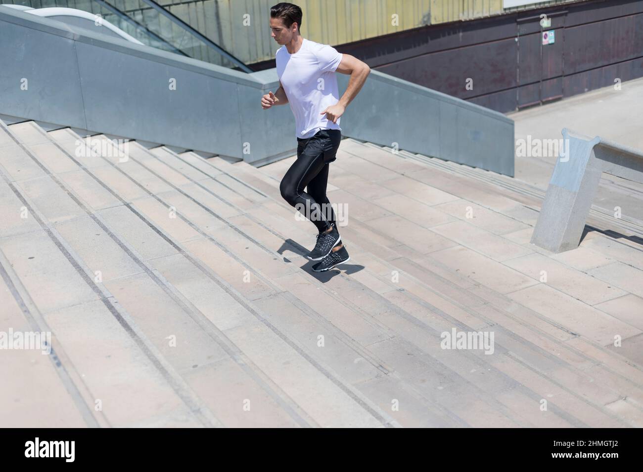 sporty man running up steps in urban setting Stock Photo - Alamy