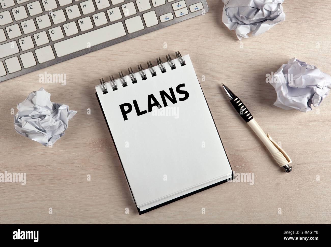 work table, a notebook with title plans a pen and crumpled paper top ...