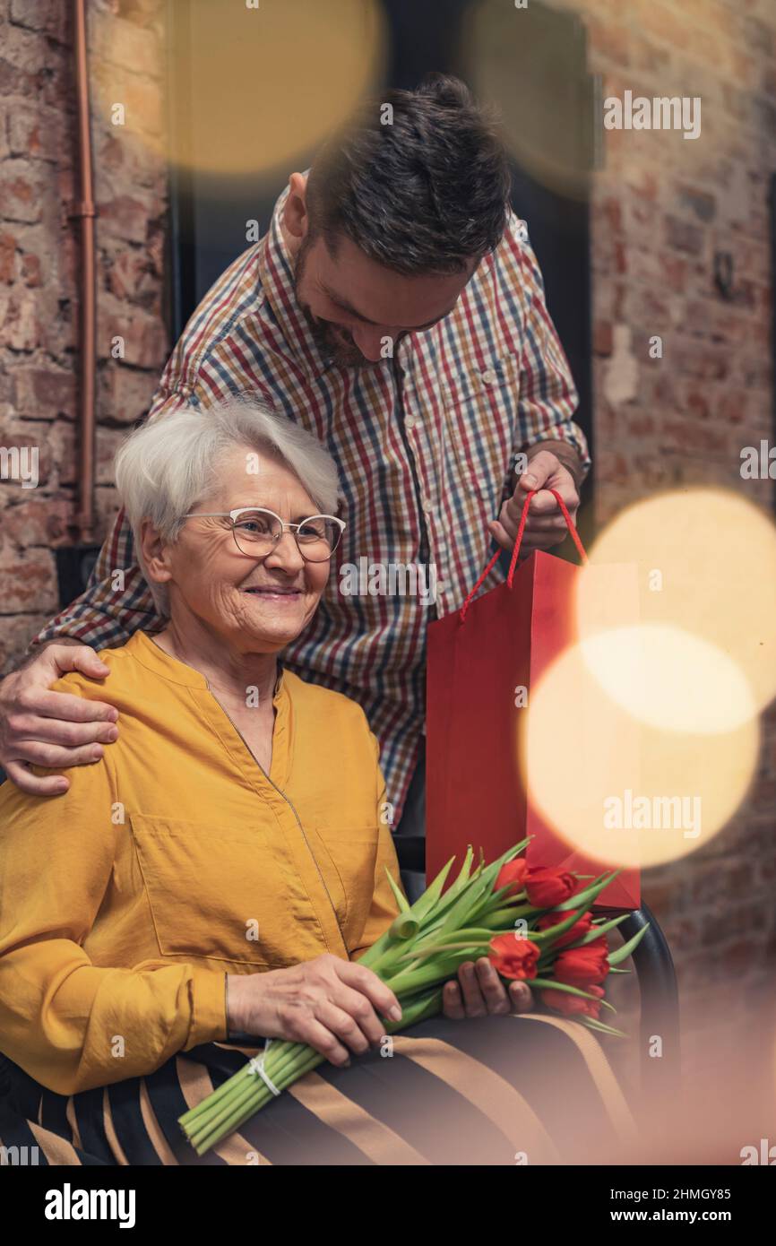 beautiful scene between elderly mother and her grown-up son giving her ...