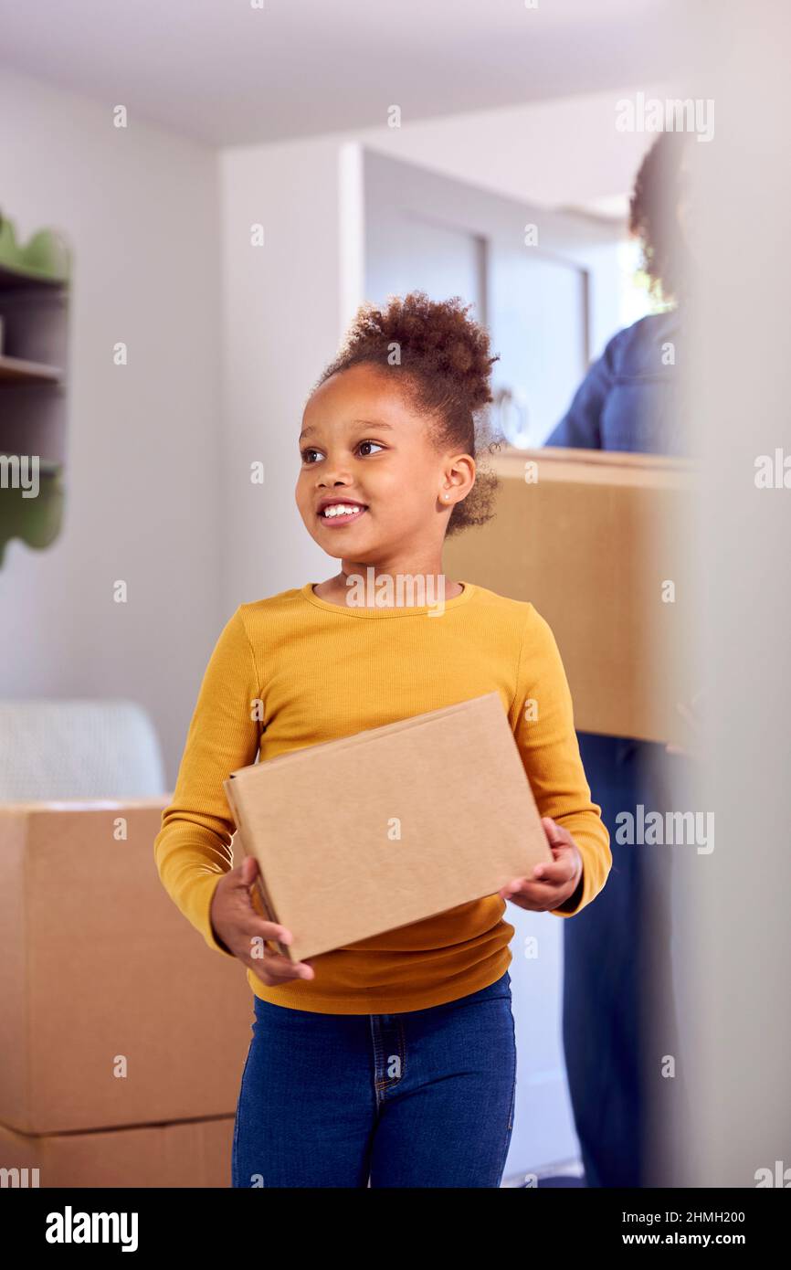 Girl Helping Mother To Carry Boxes Into New Home On Moving In Day Stock ...