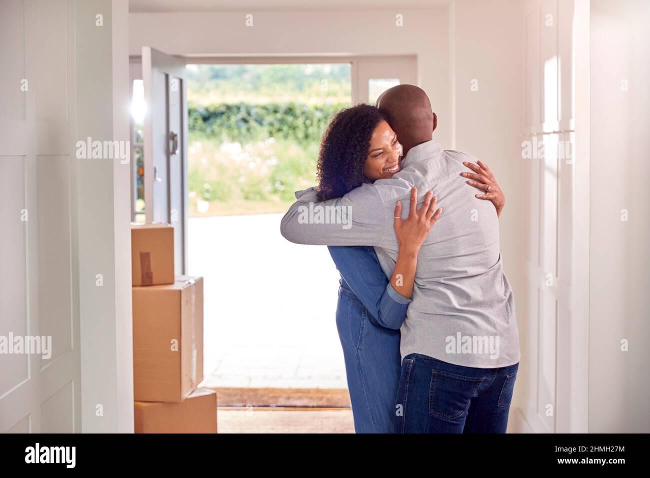 Couple Hugging In Hallway Of New Home On Moving Day Stock Photo - Alamy