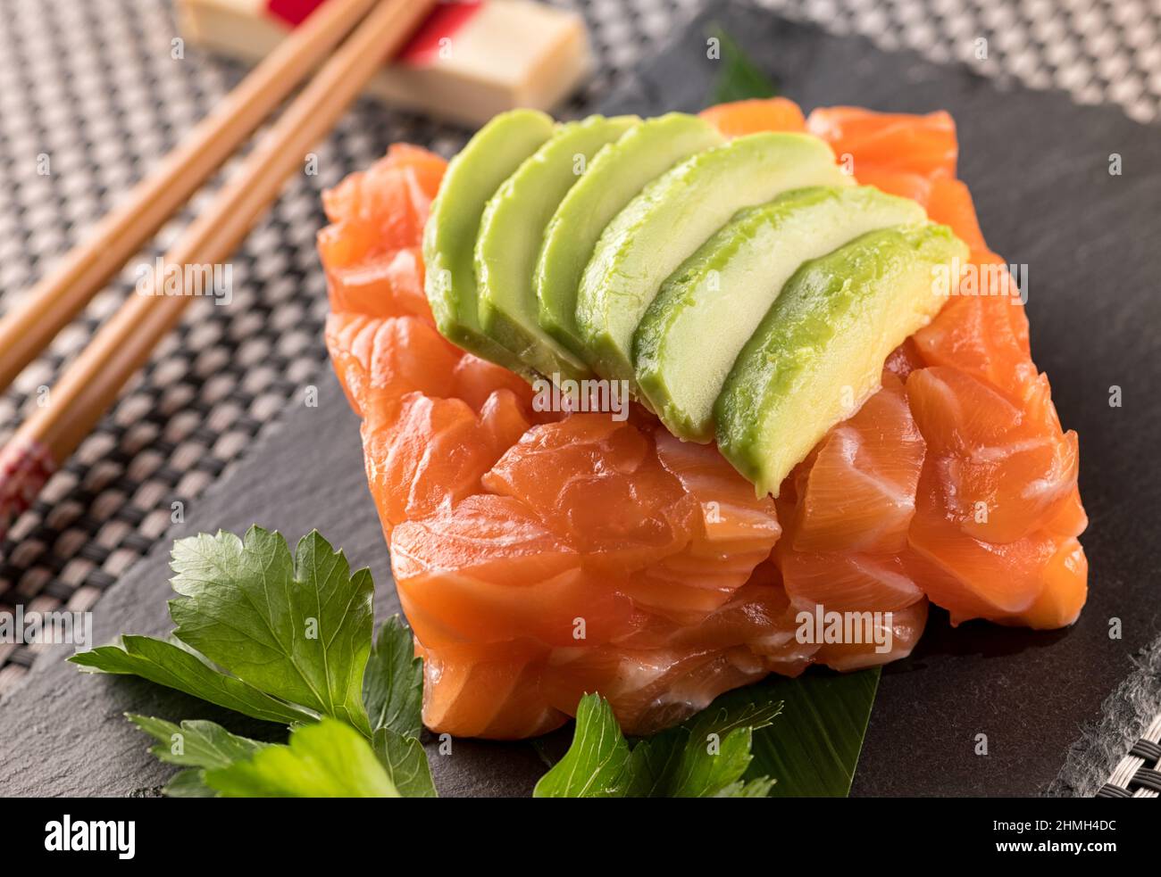 From above of fresh raw salmon tartare with slices of avocado served on ...