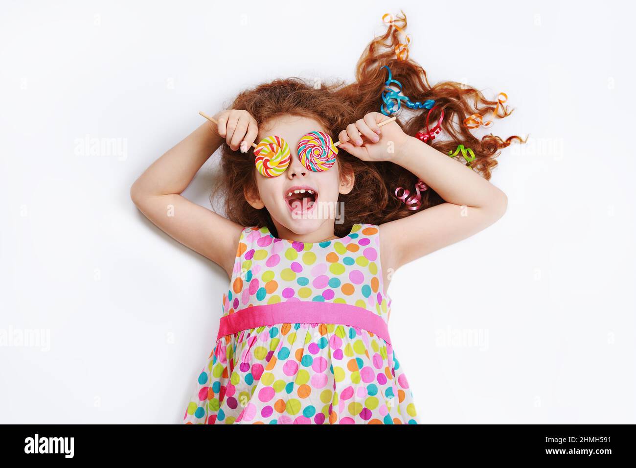 Laughing child with candy lollipop eyes in white background. High top ...